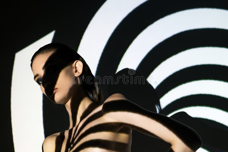 Model Poses Against Abstract Light Patterns with Striking Shadows in ...