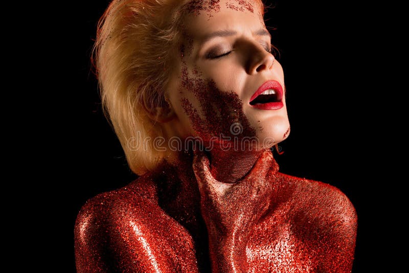 Model Adorned with Red Glitter in Striking Pose Against Black ...