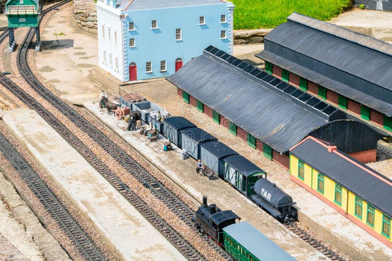 Model Train with Freight Cars on Rails with Tiny People on the Platform ...