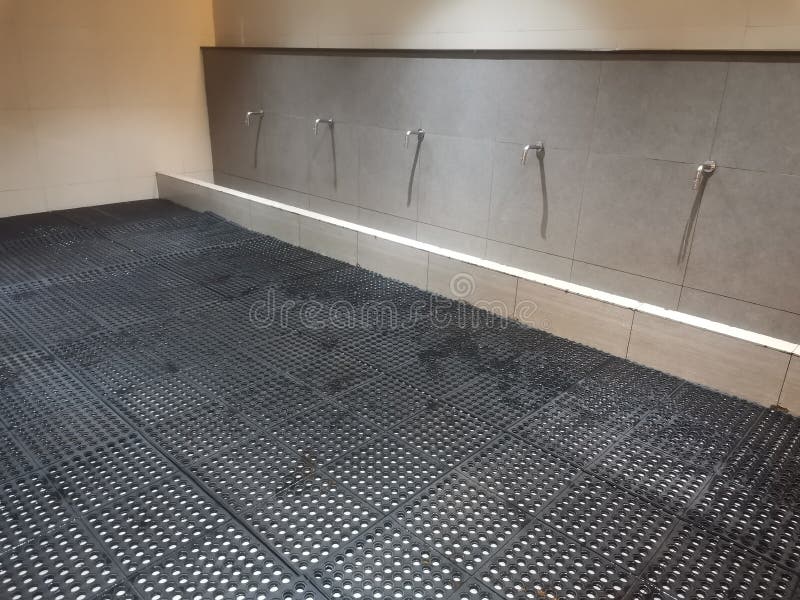 A Modern Ablution Space Featuring Rubber Flooring, Natural Stone Walls ...