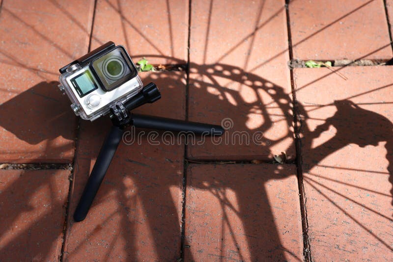 Modern Action Camera with Tripod on Pavement Outdoors, Above View ...