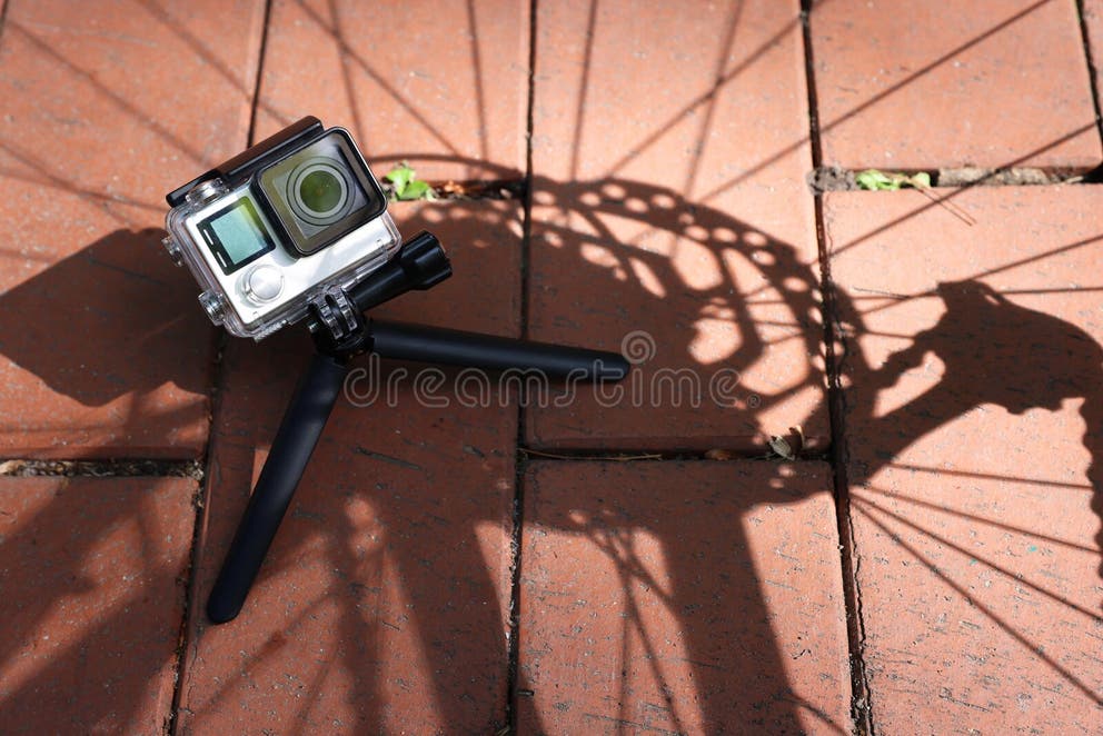 Modern Action Camera with Tripod on Pavement Outdoors, Above View ...
