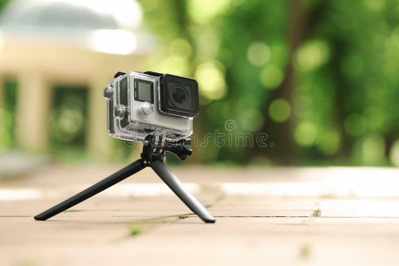 Modern Action Camera with Tripod on Pavement Outdoors, Space for Text ...