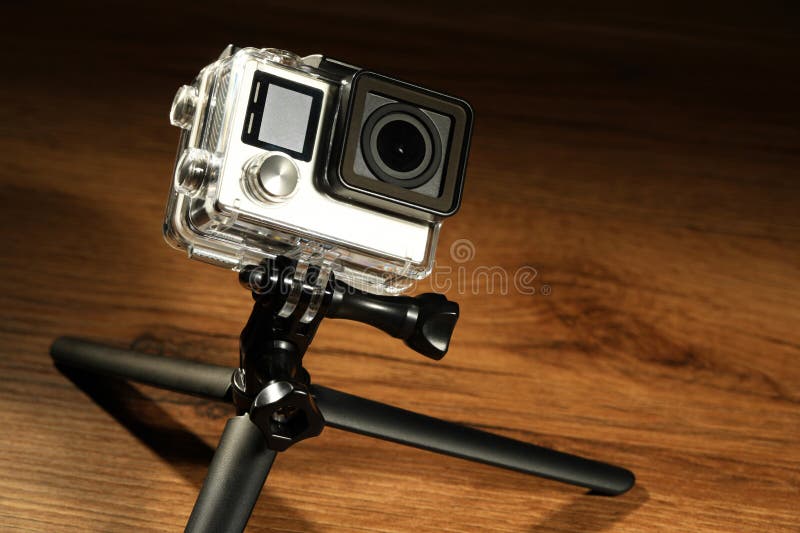 Modern Action Camera and Tripod on Wooden Surface Stock Photo - Image ...