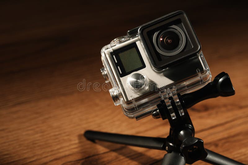 Modern Action Camera and Tripod on Wooden Surface, Closeup Stock Photo ...
