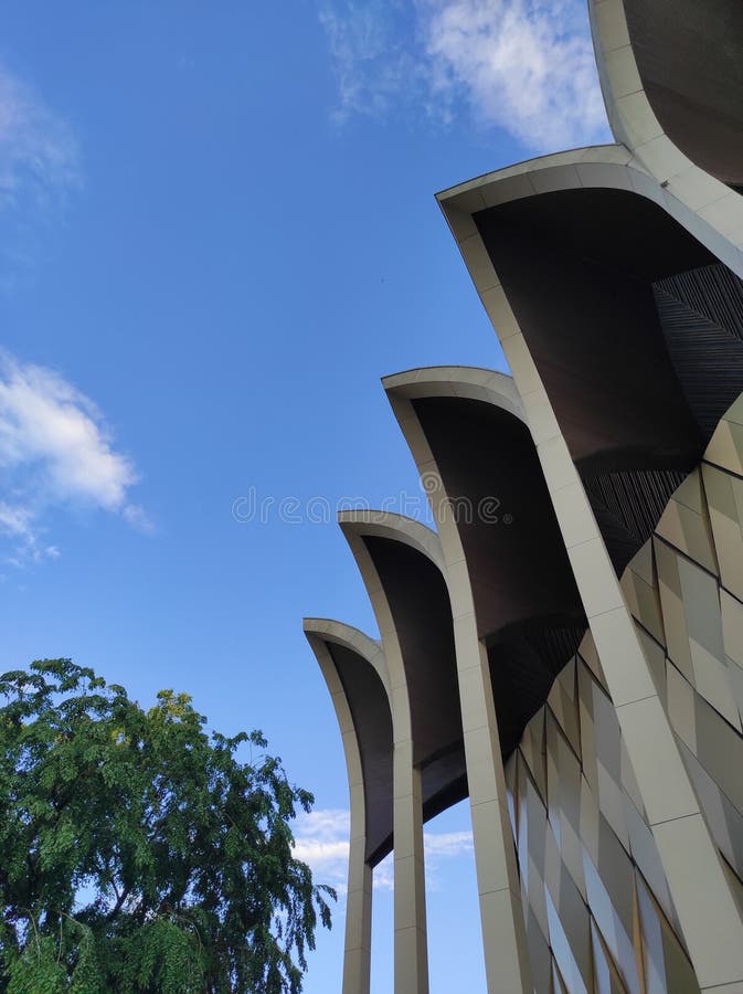 Modern Architectural Structure with Curved Roof, Clear Sky, Green Tree ...