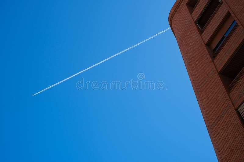 Modern Architecture and Jet Contrail Overhead Against Clear Blue Sky ...