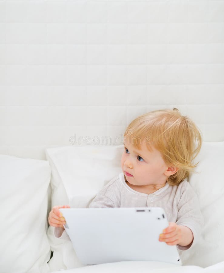 Modern baby with tablet PC stock photo. Image of bedding - 26076350