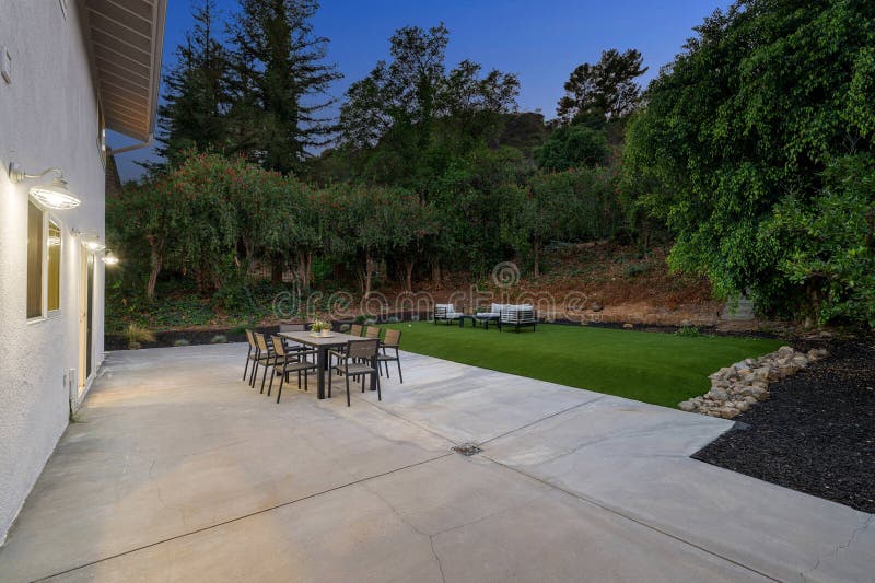 Modern Backyard Patio with Dining Set at Dusk. Stock Image - Image of ...
