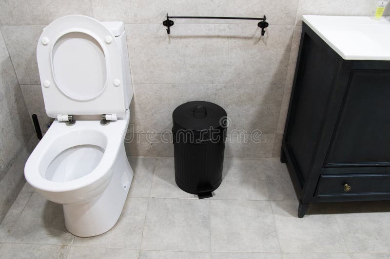 A Bathroom that Has a Toilet and Trash Can in it Stock Photo - Image of ...