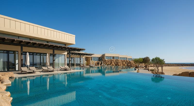 Modern Beachfront Resort with a Spacious Infinity Pool Reflecting the ...