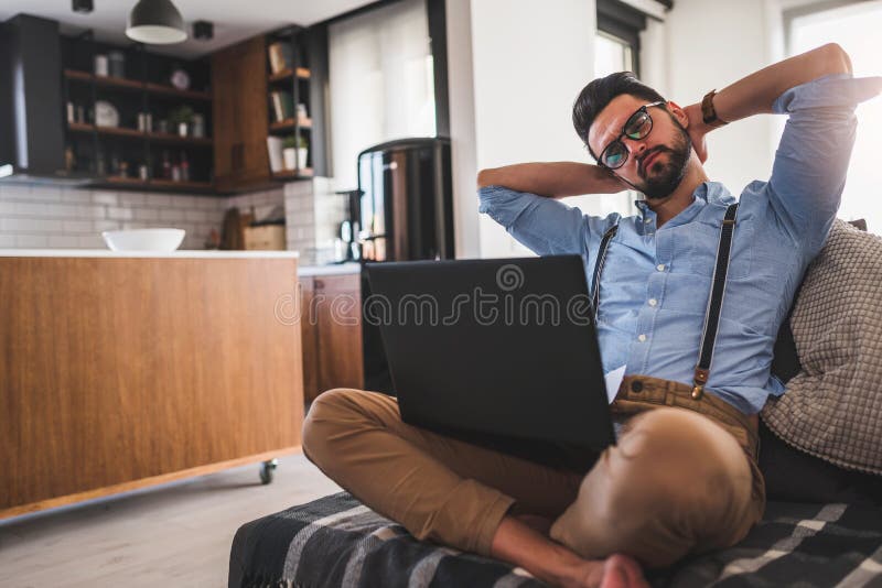 Young Businessman Working on Laptop Computer while Sitting on Sofa at ...