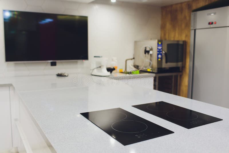 Modern Black Induction Cooker on White Countertop. Kitchen with Island ...
