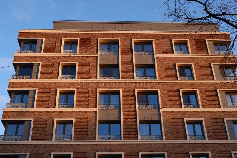 The Modern Brick Facade Elegantly Showcases Balconies and Windows in ...
