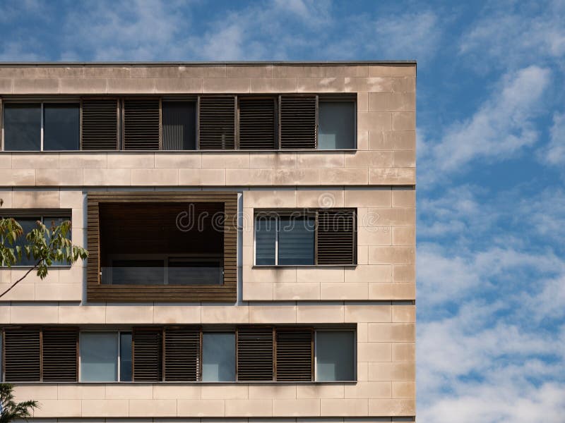 Modern Building with Balconies and Light-colored Stone Facade Under ...