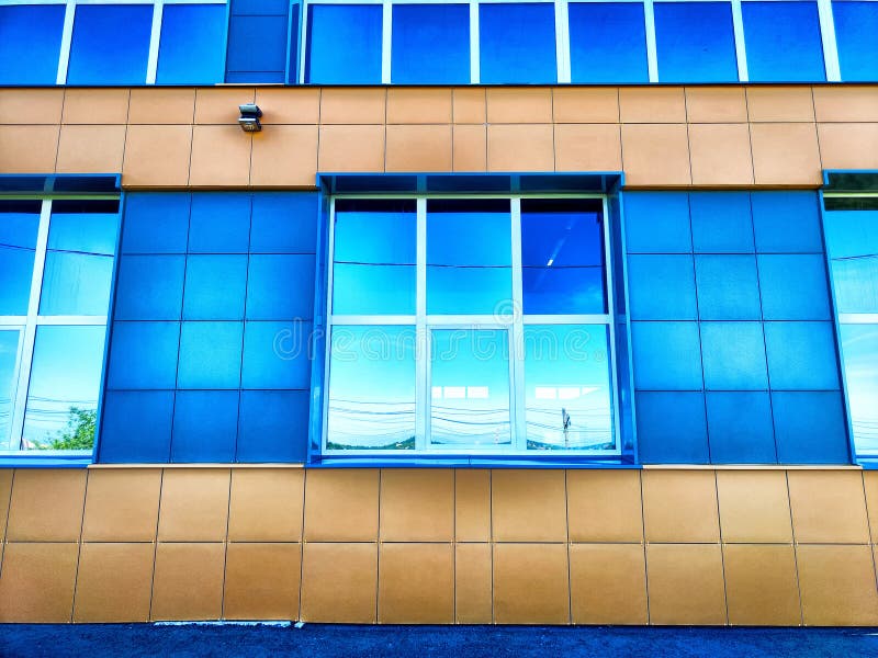 A Modern Building Facade with Blue Glass Windows and Beige Tiles Stock ...