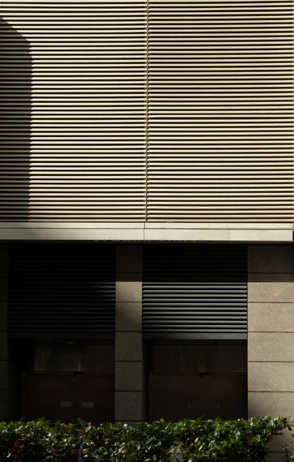 Modern Building Facade with Louvered Panels and Stone Cladding Stock ...