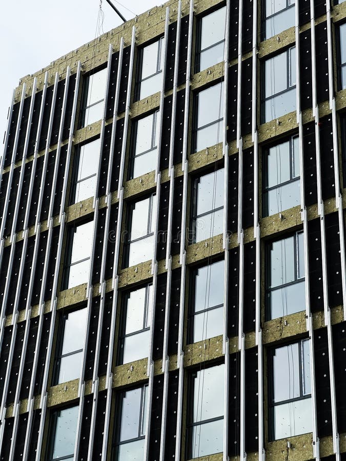 Modern Building Facade Under Construction with Reflective Windows and ...