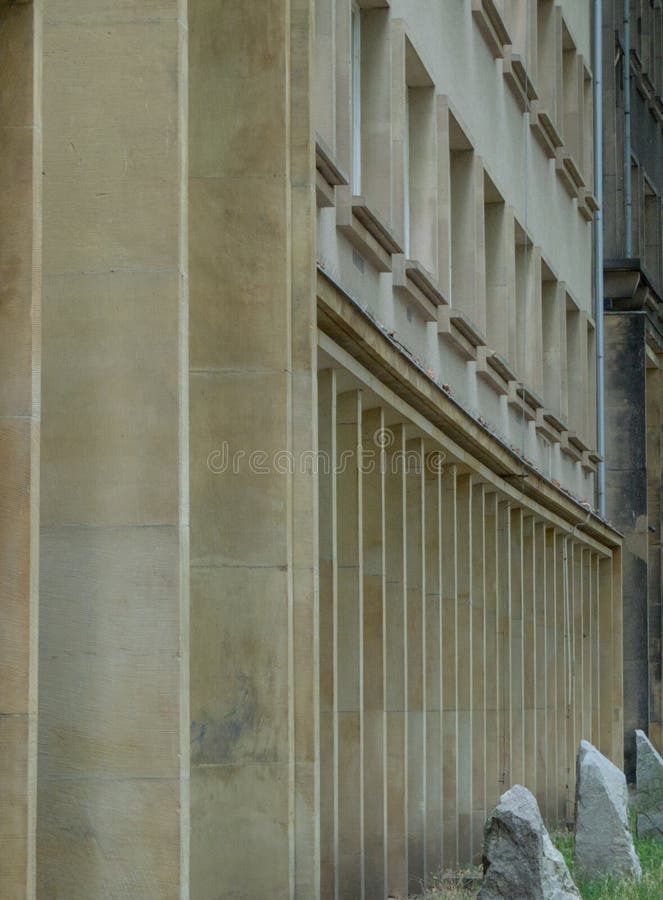 A Modern Building Facade with Vertical Panels, Windows, and Stone ...