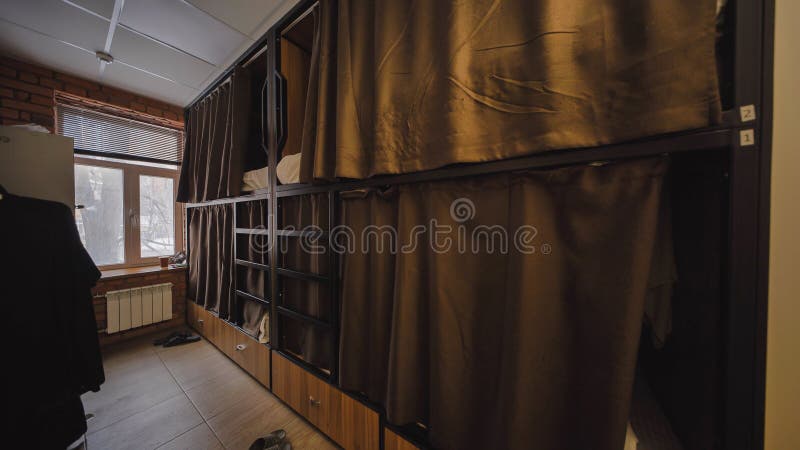 Modern Capsule Hostel Room with Brown Curtains Providing Privacy Stock ...