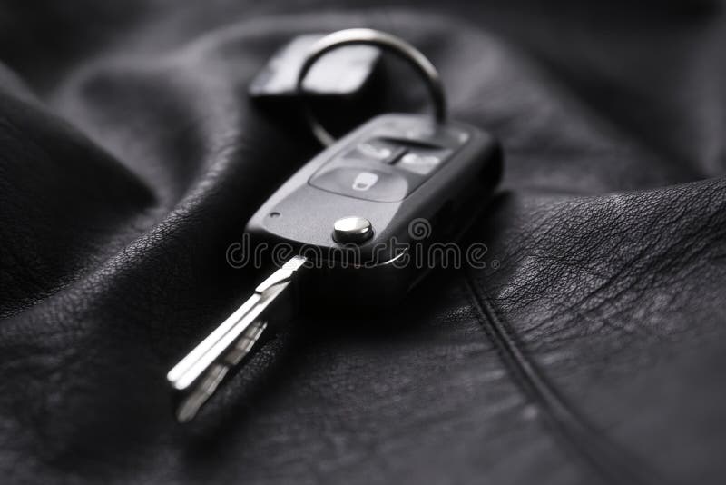 Modern Car Flip Key with Trinket on Black Leather, Closeup Stock Photo ...