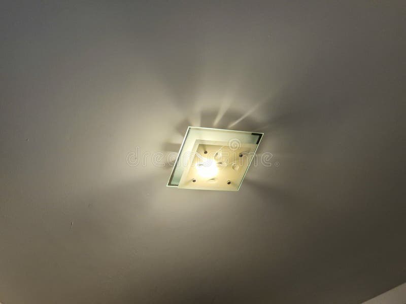 A Modern Ceiling Light Fixture Casting Soft Shadows on a Gray Surface ...