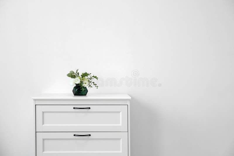 Modern Chest of Drawers with Fresh Flowers Near Wall Stock Photo ...