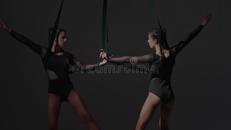 Portrait of Two Female Acrobats in Studio Isolated on Black Background ...
