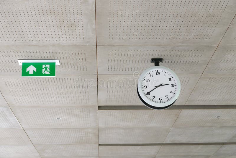 Modern Circle Clock and Exit Sign Hang on Ceiling Under Building Stock ...