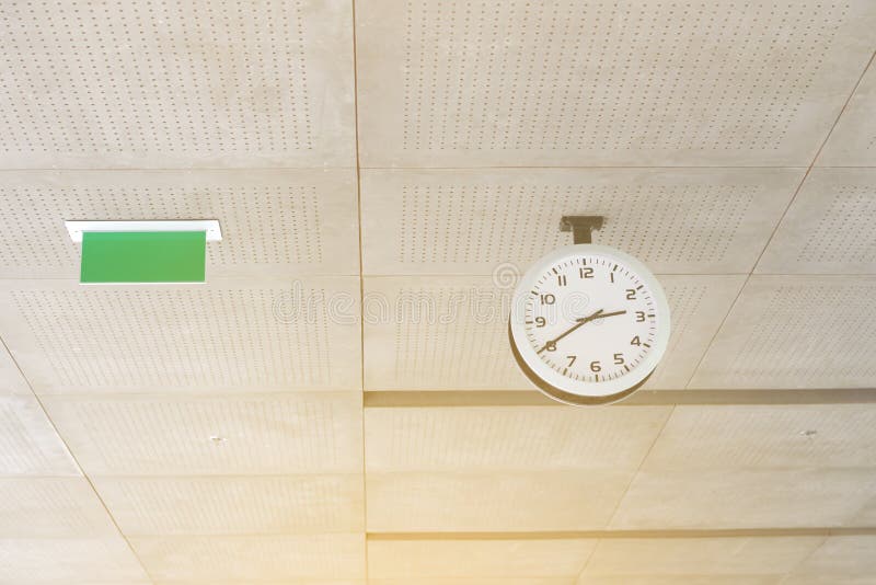 Modern Circle Clock and Exit Sign Hang on Ceiling Under Building Stock ...