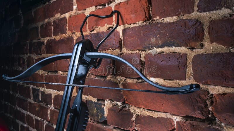 A Modern Compound Crossbow Handgun on the Red Brick Wall Background ...