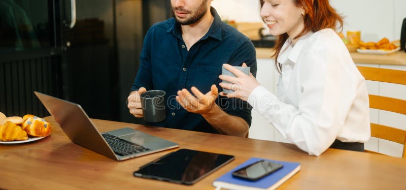 Modern Couple Collaborating Over Coffee in a Cozy Kitchen Setting with ...