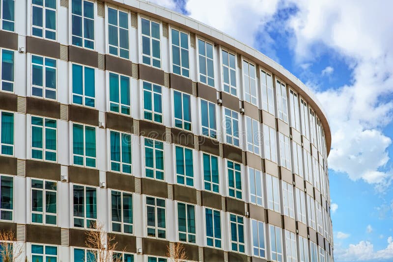 Blue Windows on Brown and Silver Curved Building Stock Image - Image of ...