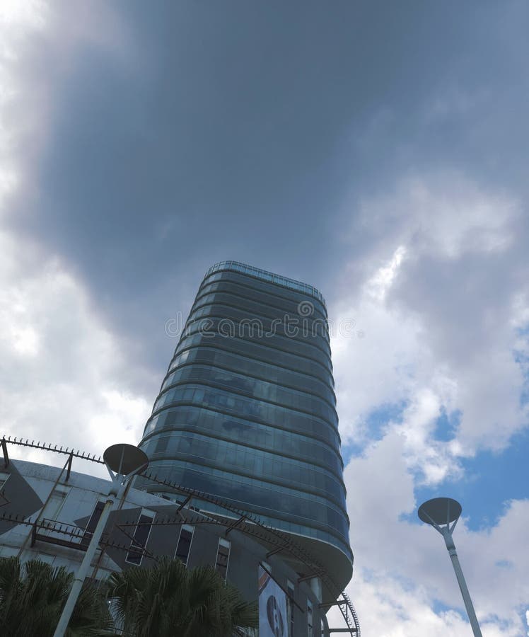 Modern Curved Glass Tower Under Dramatic Sky Stock Photo - Image of ...
