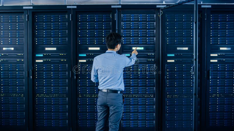 In the Modern Data Center: it Engineer Standing beside Open Server Rack ...