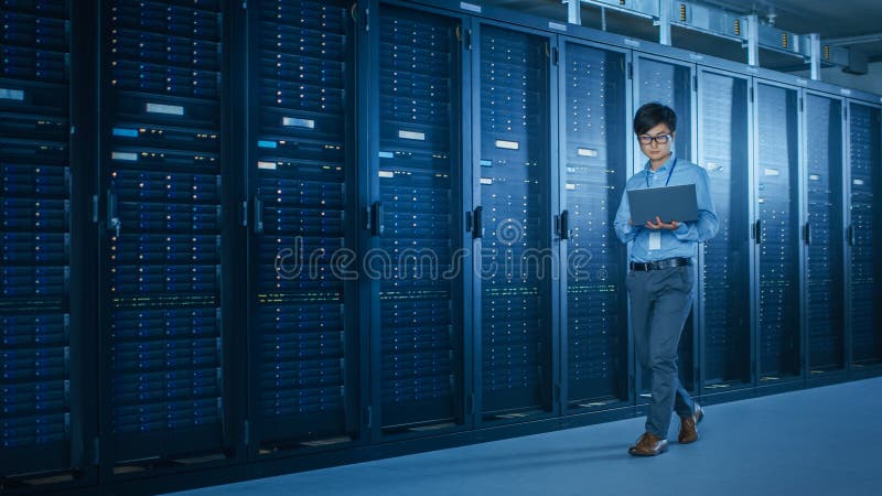 In the Modern Data Center: it Engineer Working with Server Racks, Uses ...