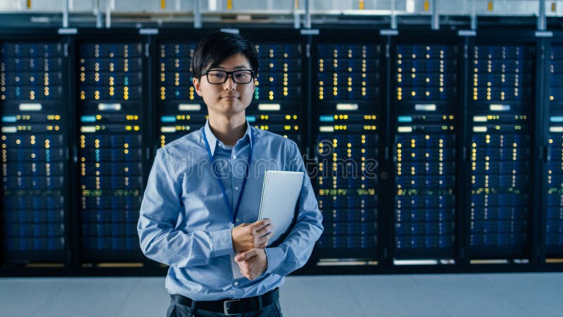In the Modern Data Center: Portrait of it Engineer Stands beside the ...