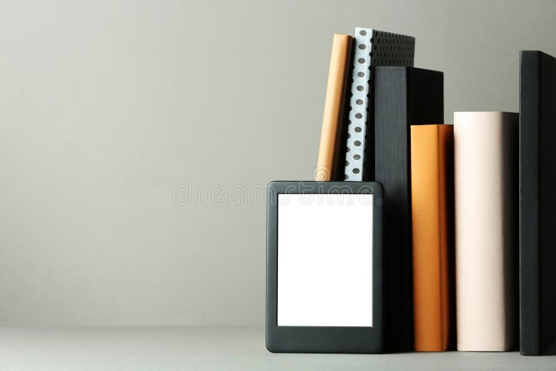 Modern E-book Reader and Hard Cover Books on Light Grey Table. Space ...