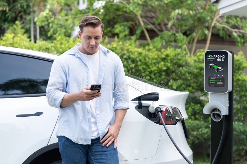 Modern Eco Man Recharge EV Car at Home with Phone. Synchronos Stock ...