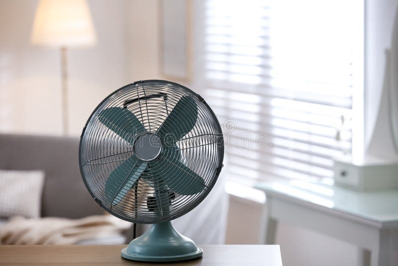 Modern Electric Fan on Wooden Table Indoors. Space for Text Stock Photo ...