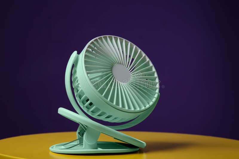 Modern Electric Fan on Yellow Table Against Violet Background Stock ...