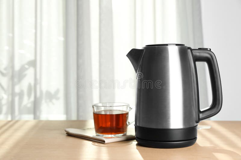 Modern Electric Kettle and Cup of Tea on Wooden Table. Space for Text ...
