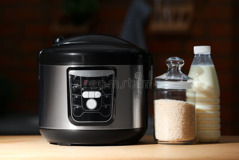 Modern Electric Multi Cooker, Rice and Milk on Table Stock Photo ...