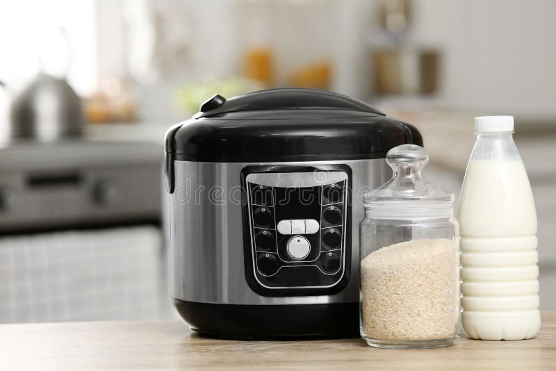 Modern Electric Multi Cooker, Rice and Milk on Table Stock Photo ...