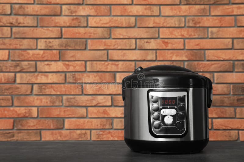Modern Electric Multi Cooker on Table Near Brick Wall. Stock Image ...