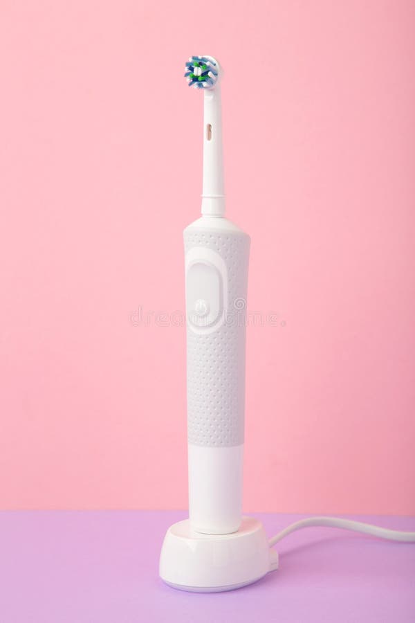 Modern Electric Toothbrush with Charger on Pink Background Stock Photo ...