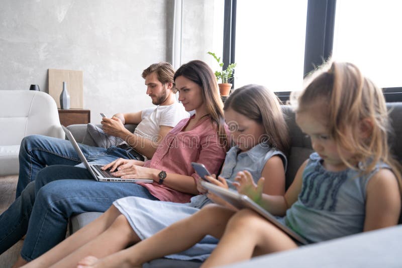 Modern Family Values. Father, Mother and Daughters Using Electronic ...
