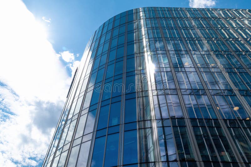 Modern Glass Building Reflecting Blue Sky and Clouds on a Sunny Day ...