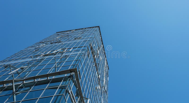 Modern Glass Skyscraper with Reflective Windows Against a Clear Blue ...