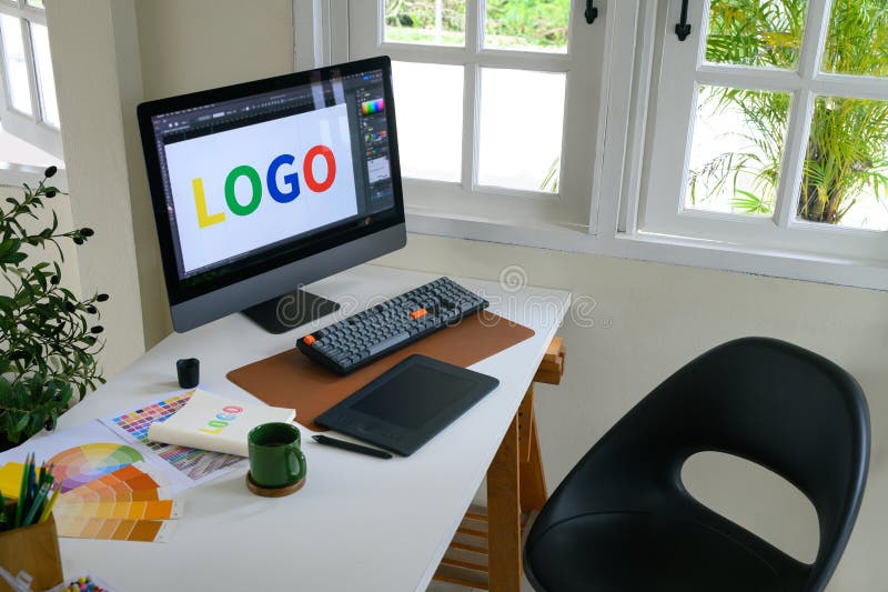 Modern Graphic Designer Workspace with Computer Showing Logo Design, Color Palette Charts, and ...